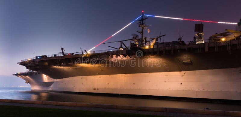 Illuminated Large Commercial Vessel Docked at a Harbor in the Evening ...