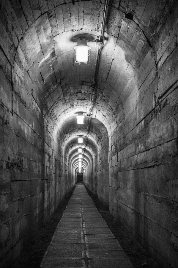 Long Underground Round Concrete Tunnel with a Pipe, Lit by Incandescent ...