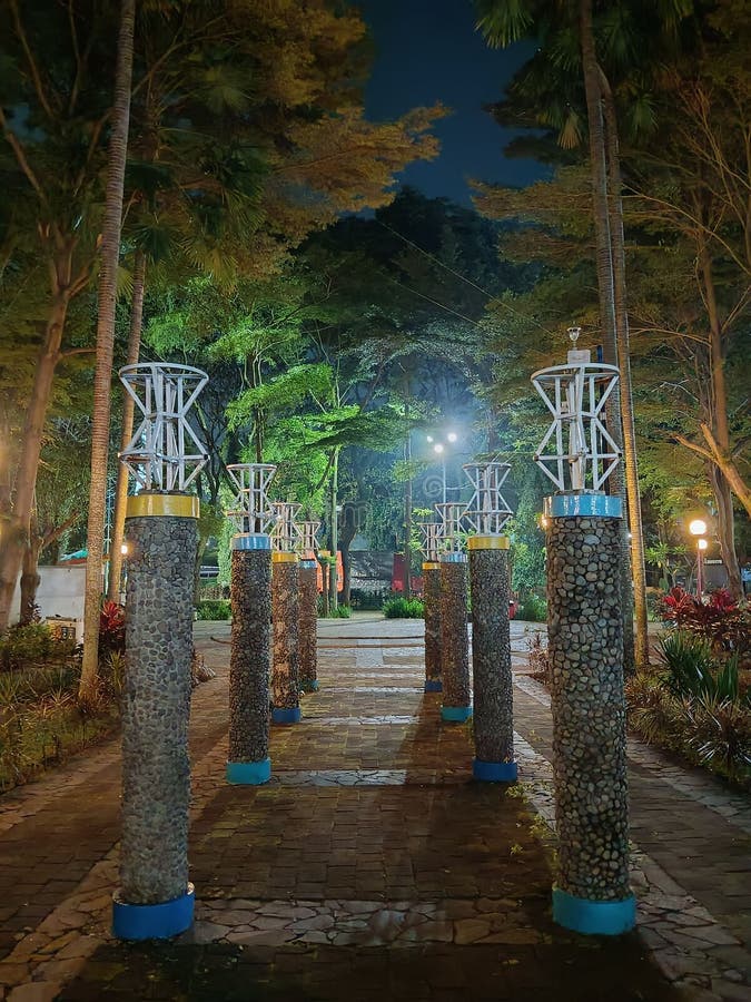 Illuminated Pathway: Nighttime Park Scene with Stone Pillars and Disc ...