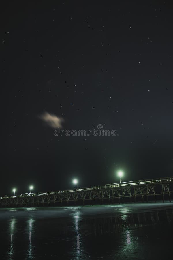 Illuminated Pier Over the Sea Water Against a Starry Night Sky Stock ...