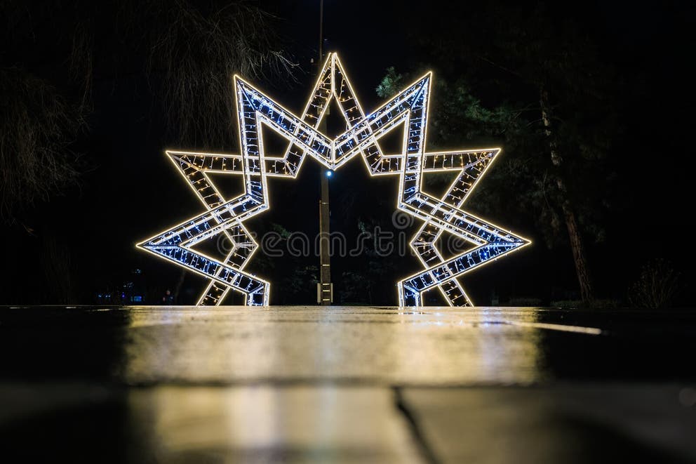 Illuminated Star Structure in Night Park with Reflections on Wet ...
