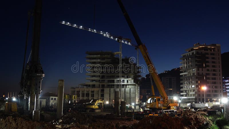 Illuminated Tower Cranes Work at a Construction Site at Night Stock ...