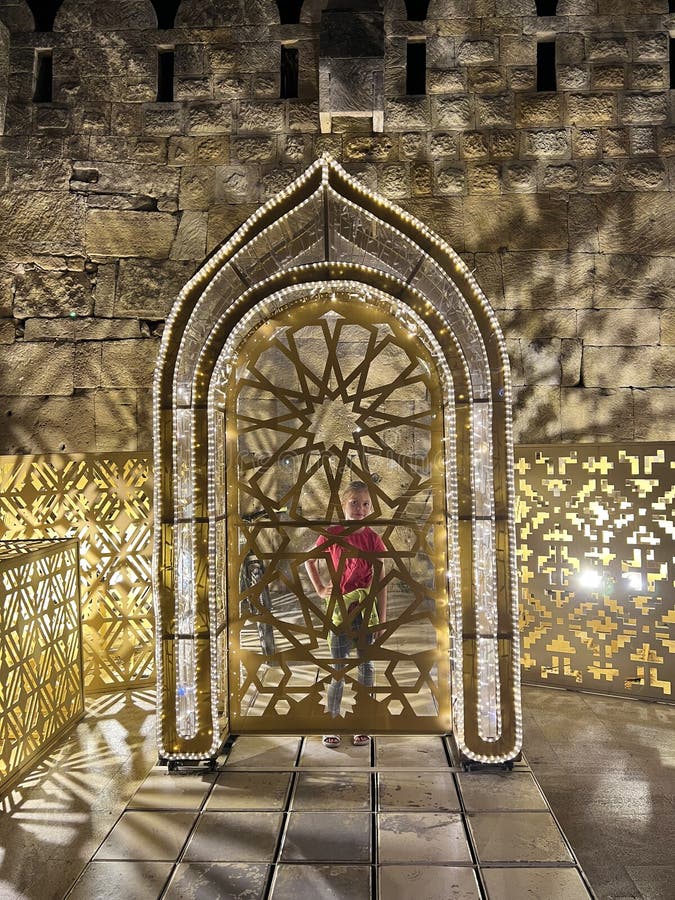 Illuminated Traditional Archway with Ornate Patterns and Stone Wall at ...