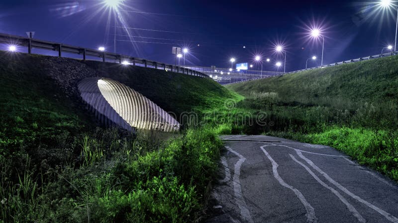 Illuminated Tunnel Under the Highway and Night Lights Stock Image ...