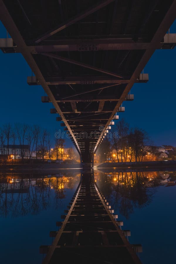 Illuminated Underpass Bridge in a Modern City by a Riverbank at Night ...