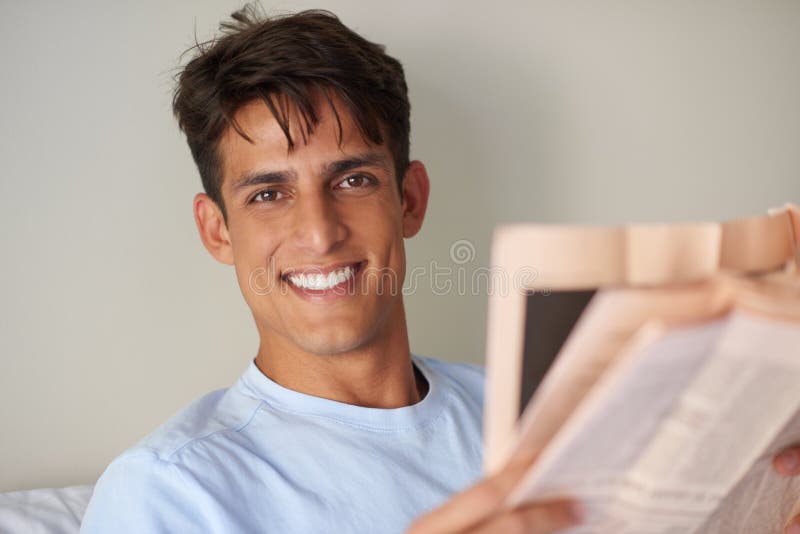 Im All about Routine. a Handsome Young Man Reading a Newspaper in His ...