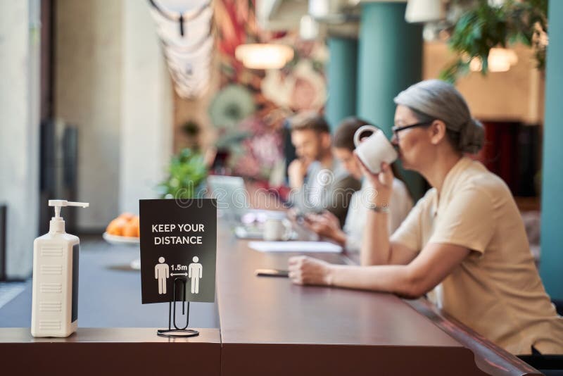 Image of Antiseptic and Sign with Text Keep Your Distance on the Table ...