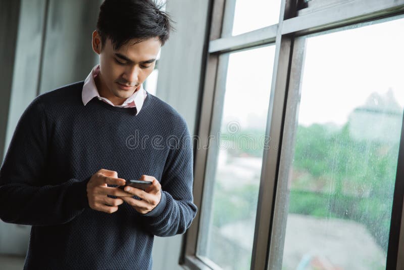 Image of Asian Young Man Holding Smartphone Stock Image - Image of ...