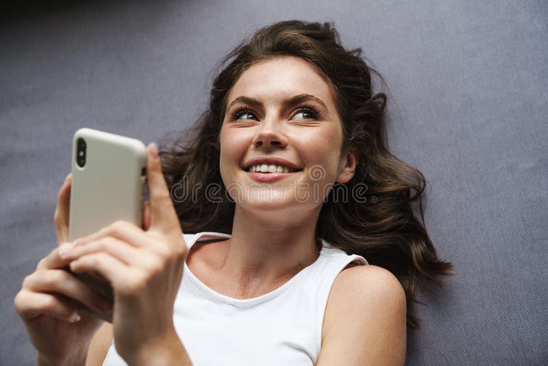 Image of Beautiful Cheerful Woman Smiling and Using Mobile Phone Stock ...