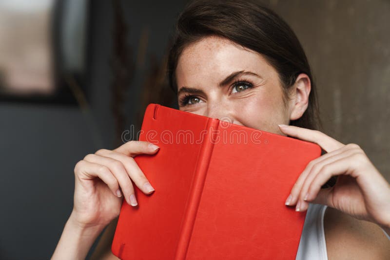 Image of Joyful Woman Putting Diary Over Her Face and Looking at Camera ...