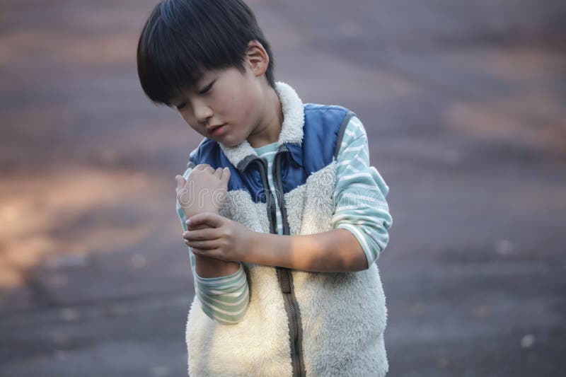 Boy holding his wrist stock photo. Image of japan, park - 324704334