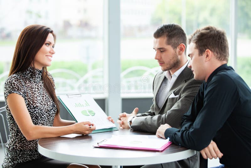 Image of Business Partners Discussing Documents and Ideas at Meeting ...