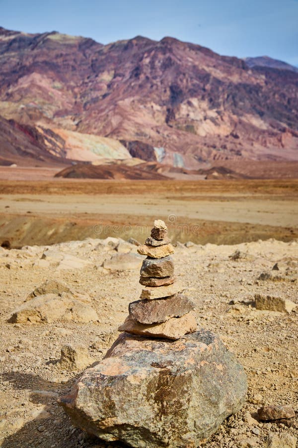 Cairn Stack of Rocks in Death Valley by Layers of Colorful Mountains ...