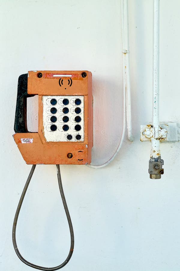 Worn Orange Telephone on a White Background Next To a Pipe Stock Image ...