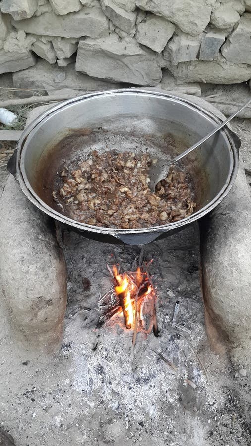 Stone Wall and Firepit with Traditional Dish Cooking for Guests Stock ...