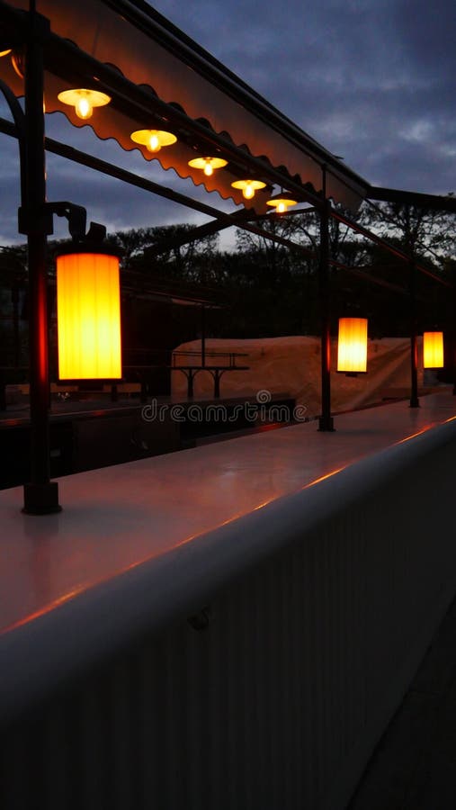 Empty Bar Counter with Lanterns and Lamps, Warm Glow Under a Cloudy Sky ...