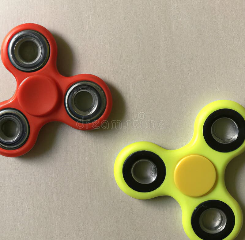 Image of Close Up of Red and Yellow Fidget Spinner on Grey Background ...