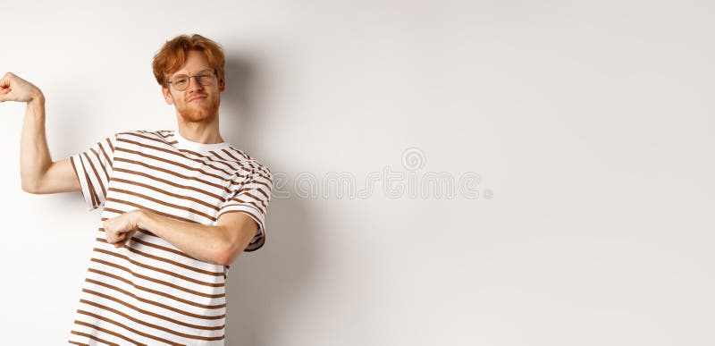 Image of Confident and Strong Redhead Man Flexing Biceps, Showing ...