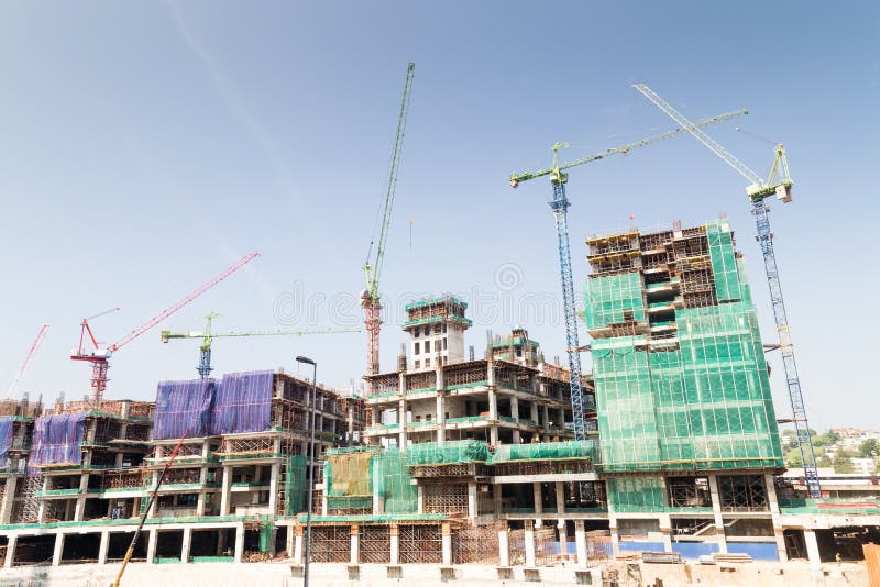 Image of Construction Site Against Blue Sky with Multiple Tower Cranes ...