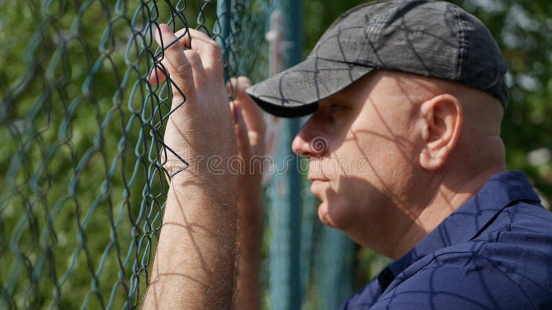 Image with a Desperate Man Looking Worried Behind a Metallic Wall ...
