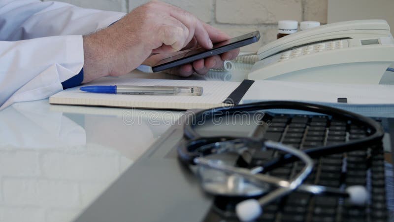 Image with a Doctor in Medical Office Texting Using a Cell Phone, Using ...