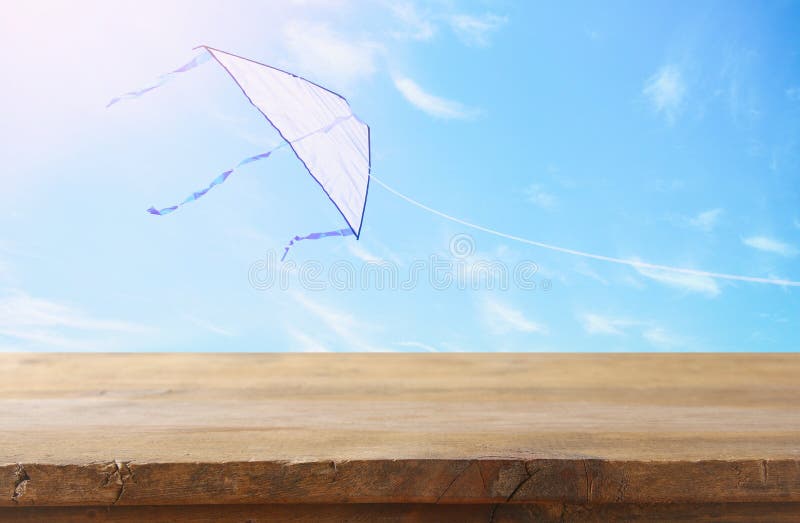Image of Empty Rustic Table in Front of Colorful Kite Flying in the ...