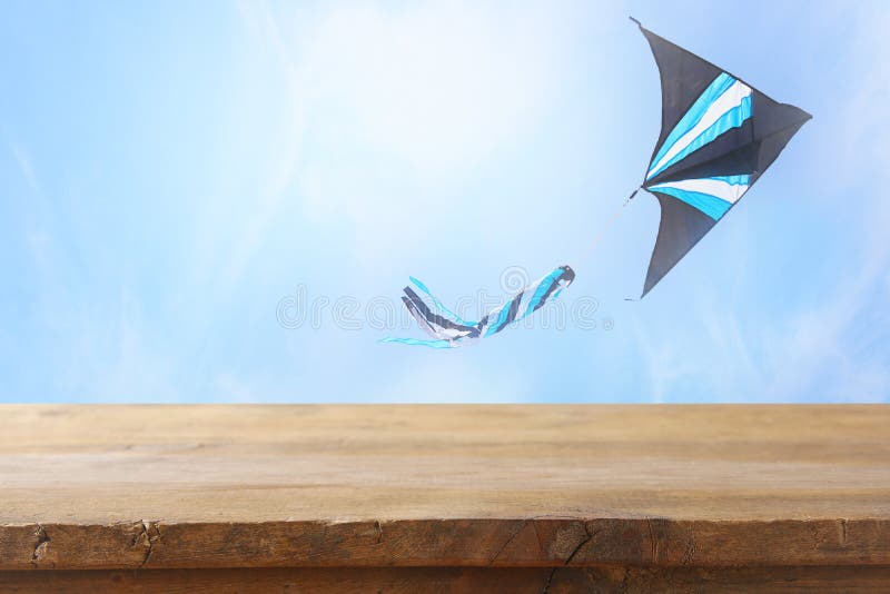 Image of Empty Rustic Table in Front of Colorful Kite Flying in the ...