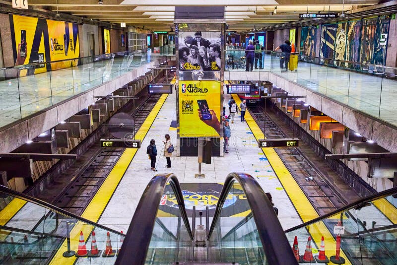 Escalator View Down into Subway with People Standing on Platform ...