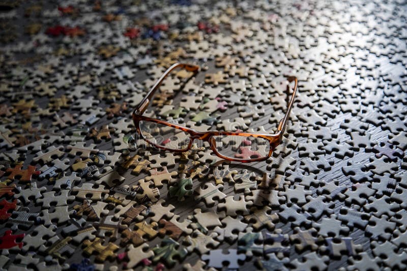 Image of Eye Glasses Casting a Shadow on a Large Group of Puzzle Pieces ...