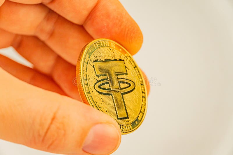 Image Features a Person Holding a Gold Tether Coin Blurred Background ...
