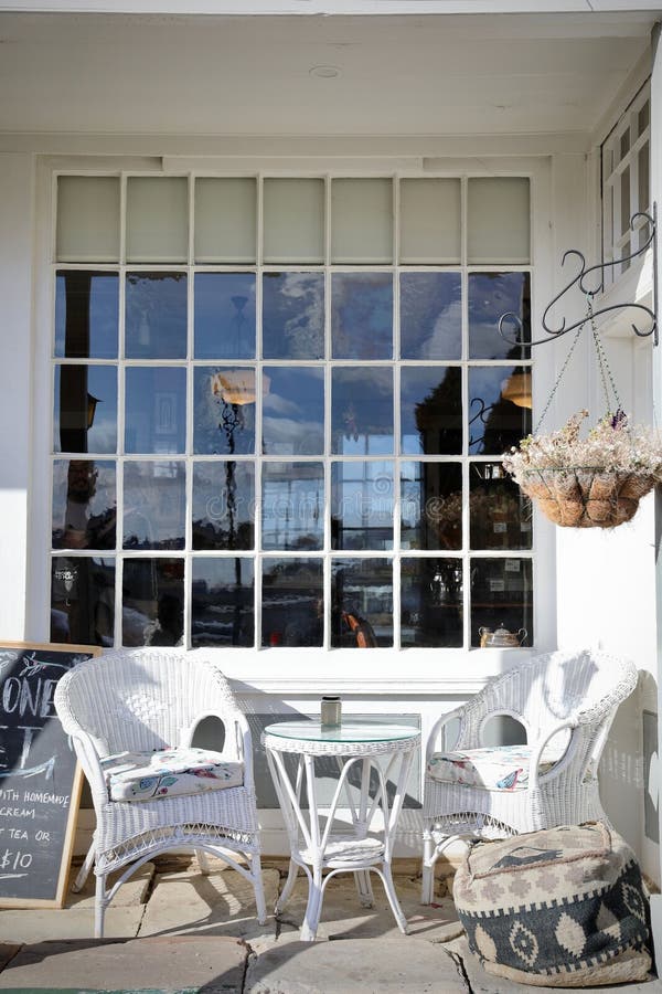 Two Chairs and a Table Outside a Store Front Window with Signs Stock ...