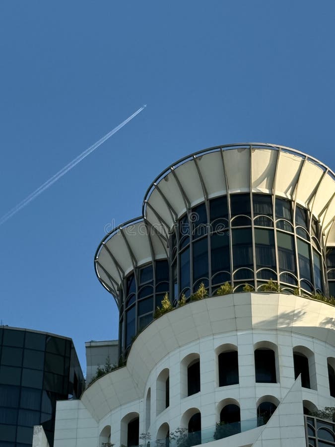 A Modern White and Glass Building with Curved Architecture Beneath a ...