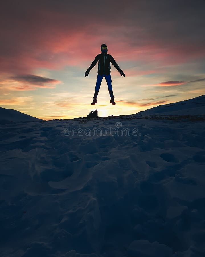 Image of a Flying Person Above Snow during a Sunset Stock Photo - Image ...