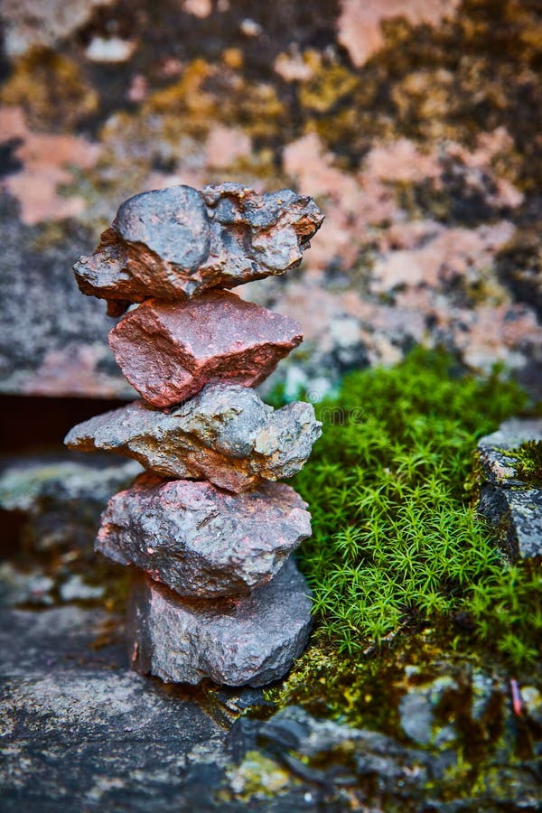 Focus on Cairn Stone Stack of Tiny Rocks Nested Against Mossy Rocks and ...