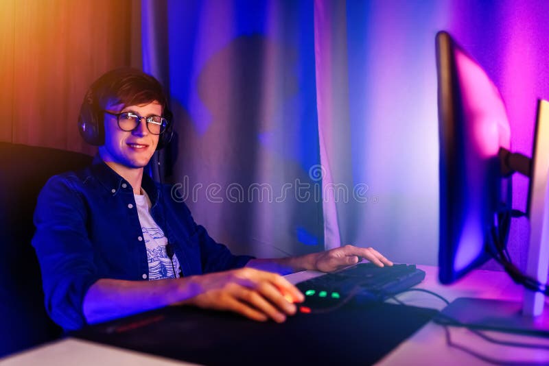 Gamer Playing Computer Games Online with Headphones, in a Room with ...