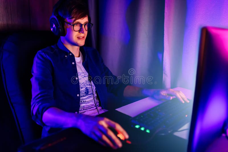 Gamer Playing Video Games on a Computer with Headphones and Using a ...
