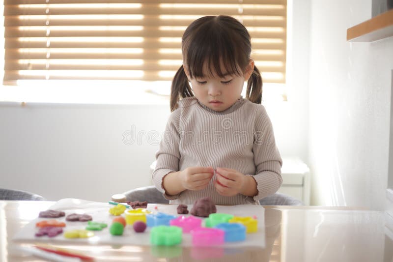 Girl playing with clay stock image. Image of living - 325012985