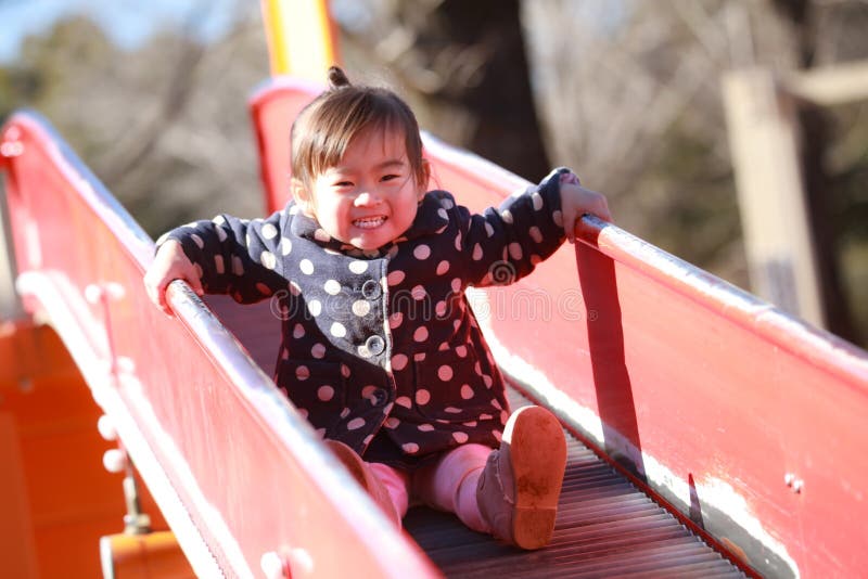 Girl playing on the slide stock image. Image of asia - 242148381