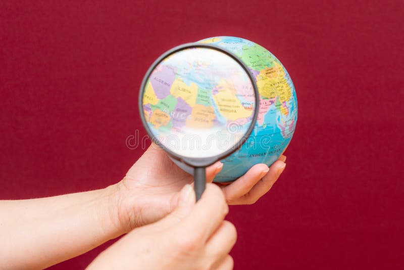 Image of a Hand Holding a Magnifying Glass Over an World Globe Stock ...