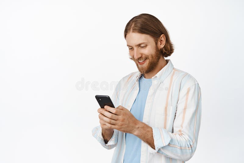 Image of Handsome Caucasian Guy Using Mobile Phone, Looking at ...