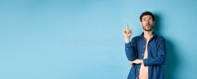 Image of Handsome Man Pitching an Idea, Raising Finger and Looking Up ...