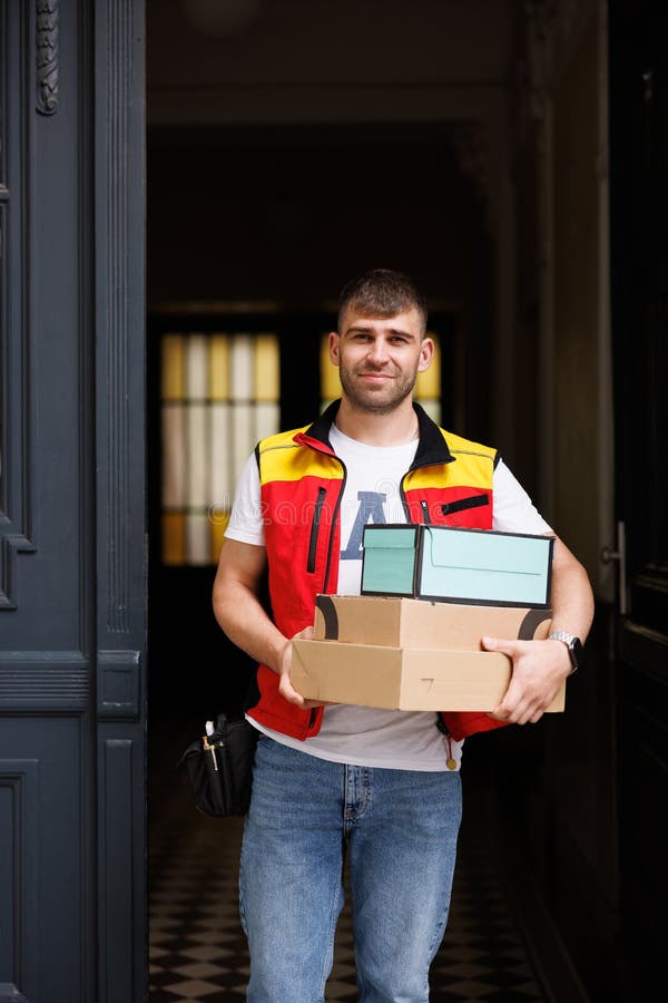 Image of Happy Young Delivery Man Standing with Parcel Post Box Stock ...