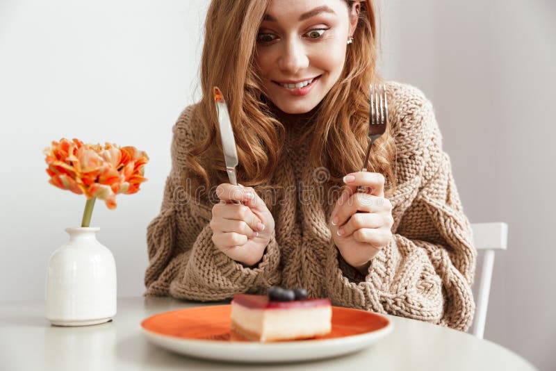 Image Of Hungry Woman Sitting At Table And Eating Cake With App Stock