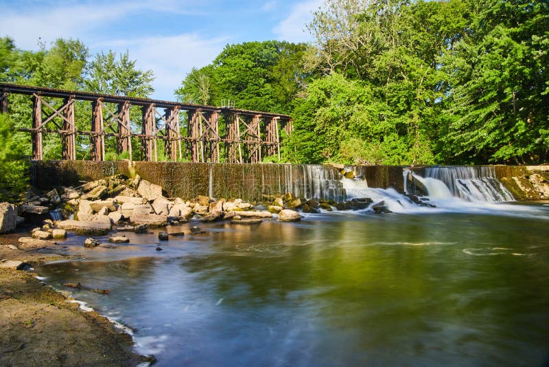 Large Dam Blocking River and Creating Waterfalls with Railroad Bridge ...