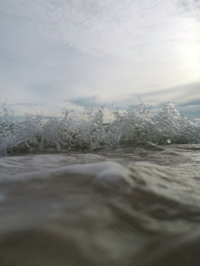 Low Angle Shot from the Beach Towards the Incoming Sea Tide at Evening ...