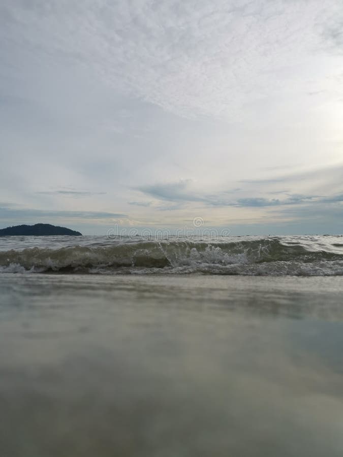 Low Angle Shot from the Beach Towards the Incoming Sea Tide at Evening ...