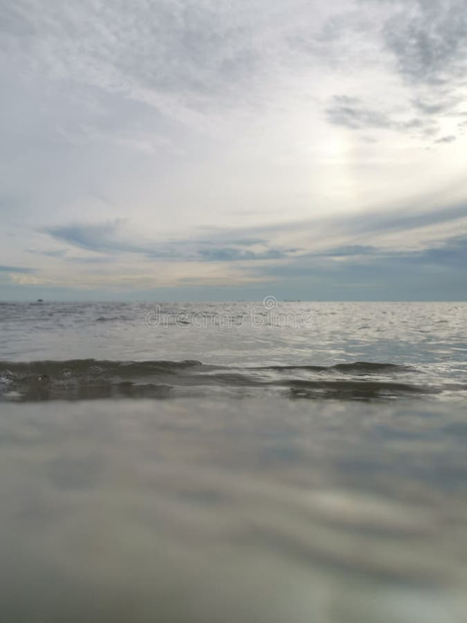 Low Angle Shot from the Beach Towards the Incoming Sea Tide at Evening ...