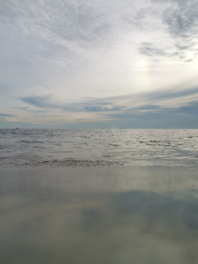 Low Angle Shot from the Beach Towards the Incoming Sea Tide at Evening ...