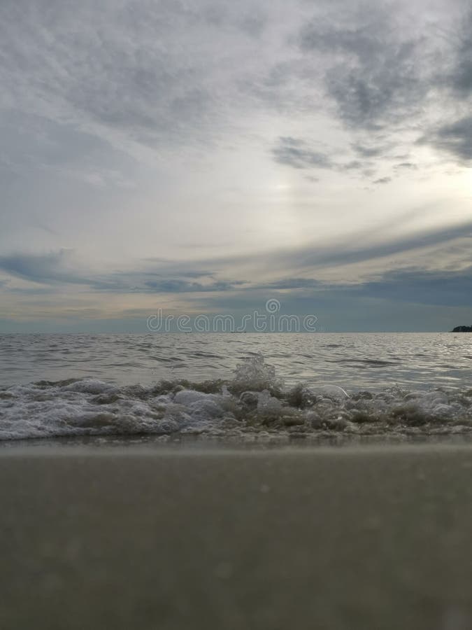 Low Angle Shot from the Beach Towards the Incoming Sea Tide at Evening ...
