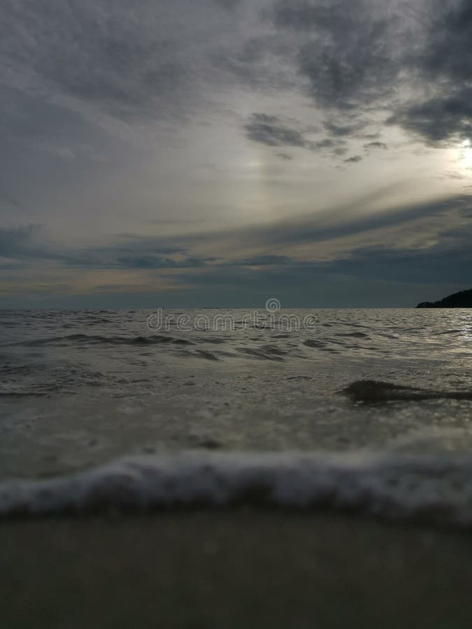 Low Angle Shot from the Beach Towards the Incoming Sea Tide at Evening ...